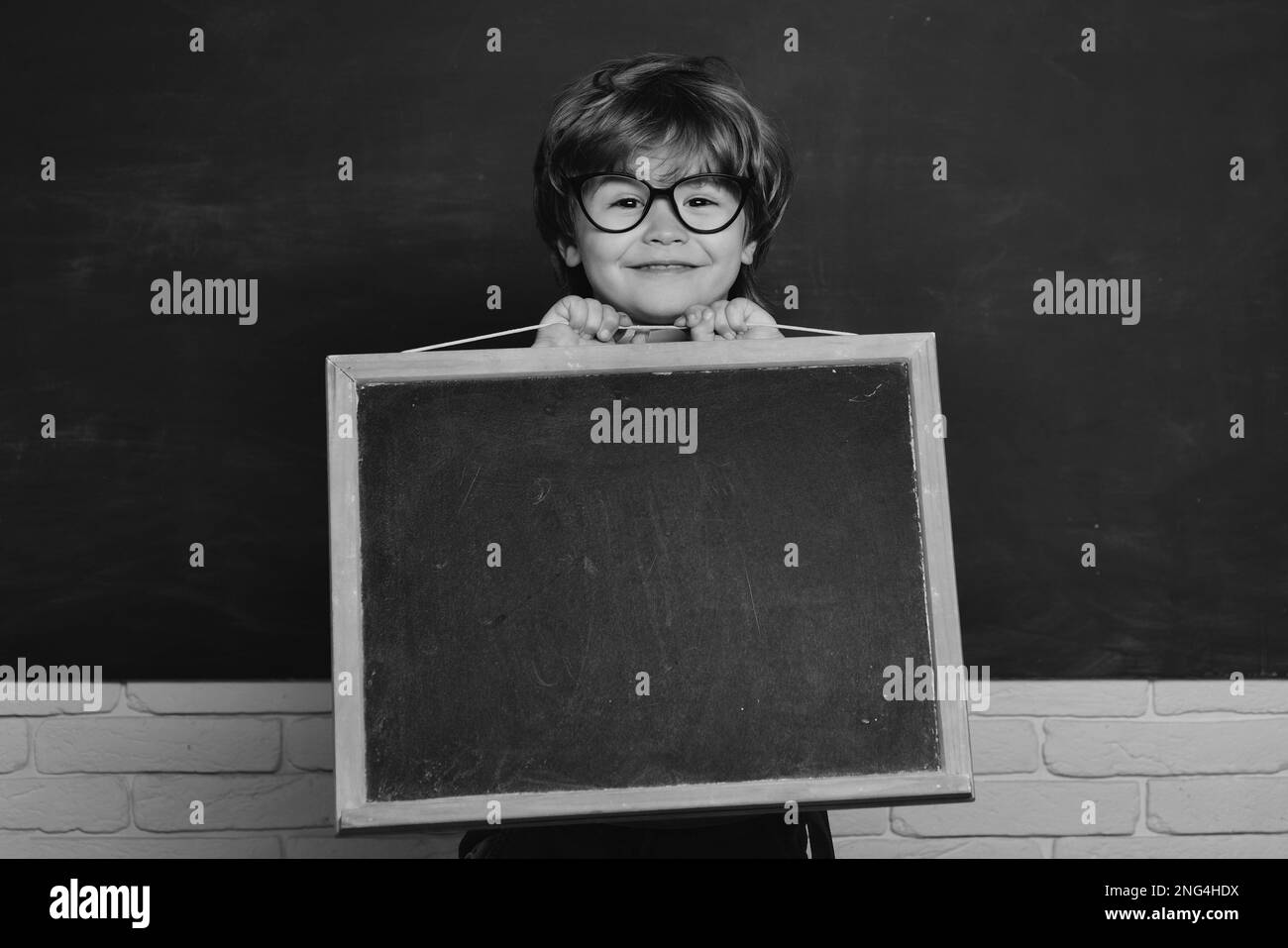 Funny little boy pointing up on blackboard. School children. School ...