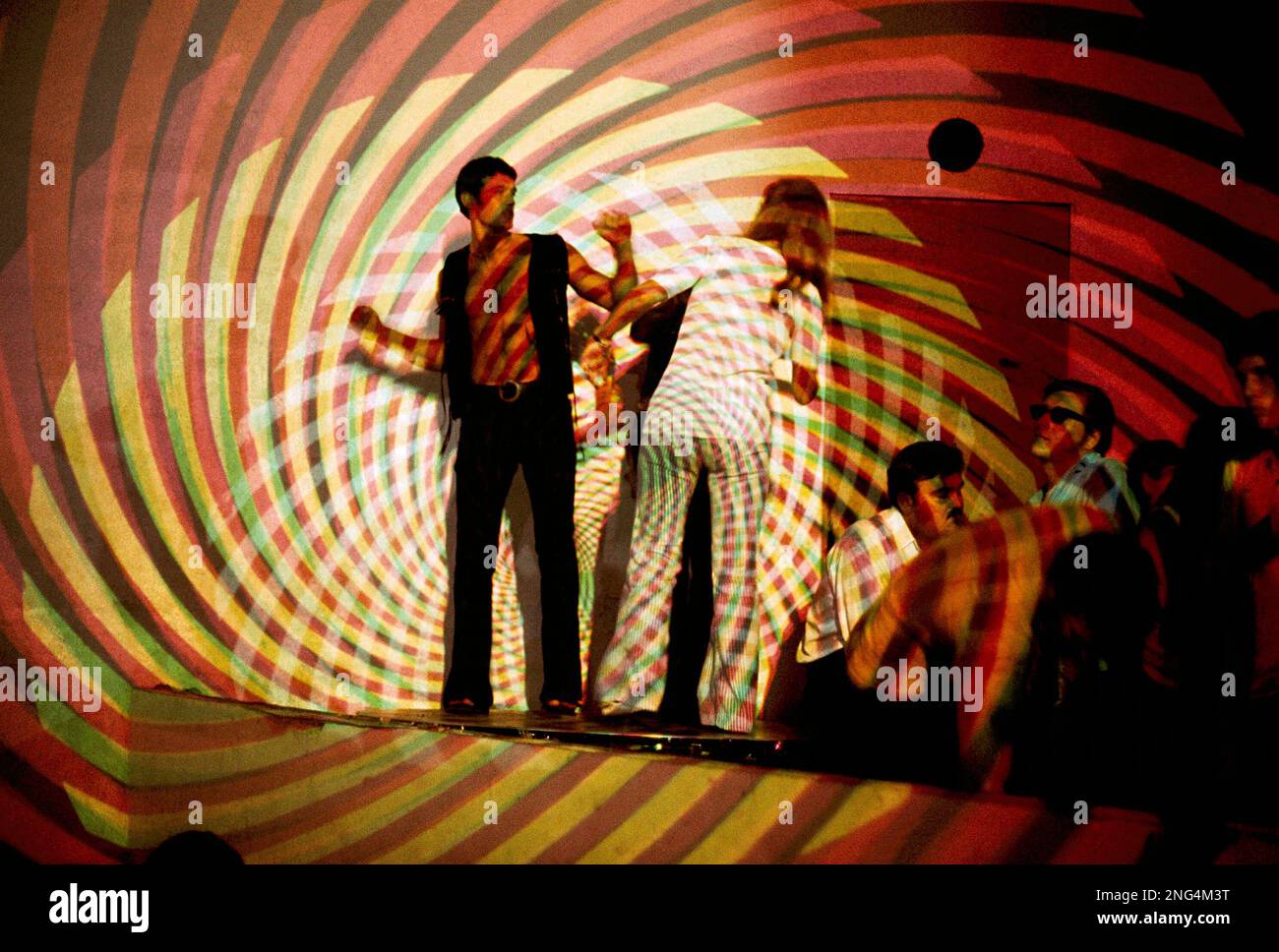 A young couple dance under a psychedelic light show at "The Electric ...