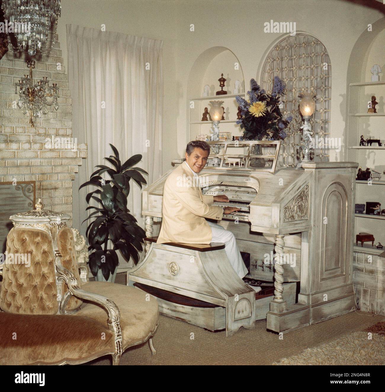 Entertainer Liberace is seated at his organ in his Hollywood Hills home ...
