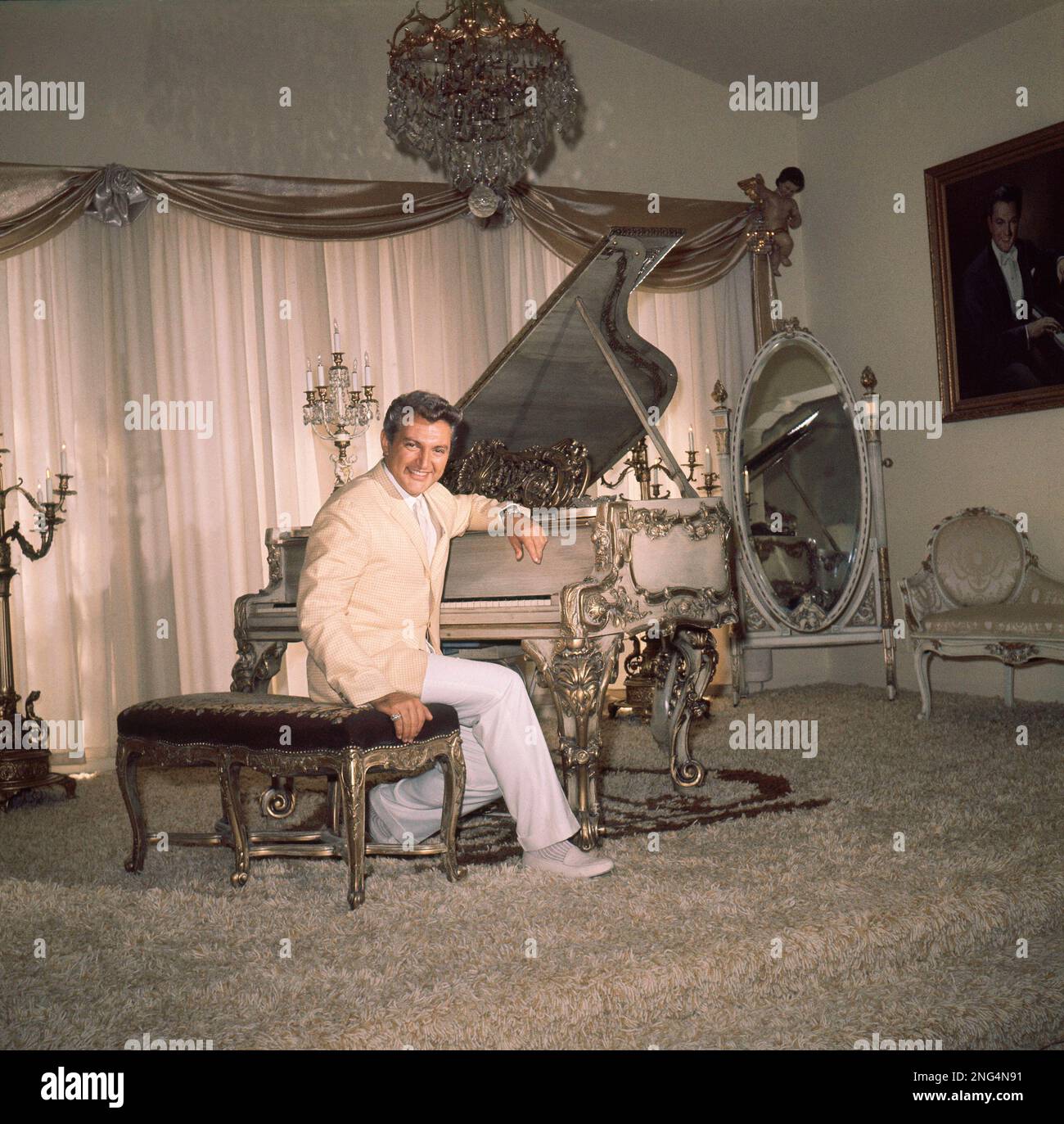 Entertainer Liberace is seated at his piano in his Hollywood Hills home ...