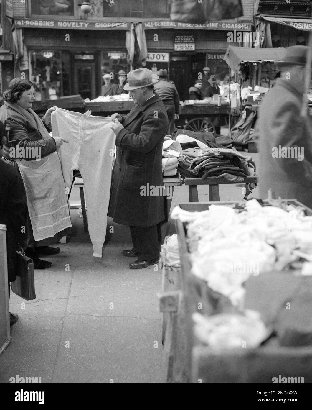 A prospective customer examines a pair of "longies" at a sidewalk ...