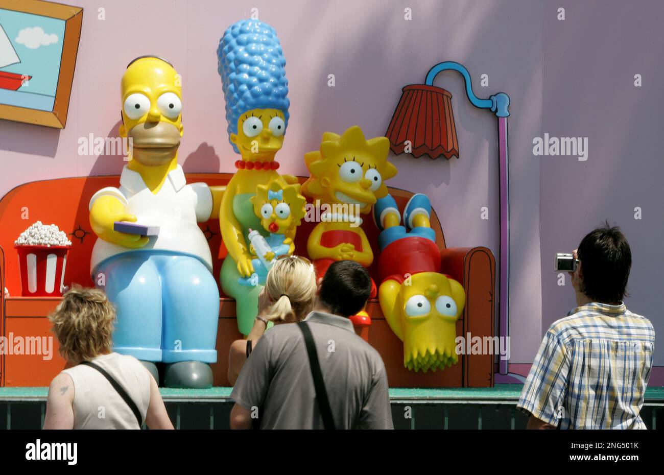 People stop to look at a scene from "The Simpsons" on display along the ...