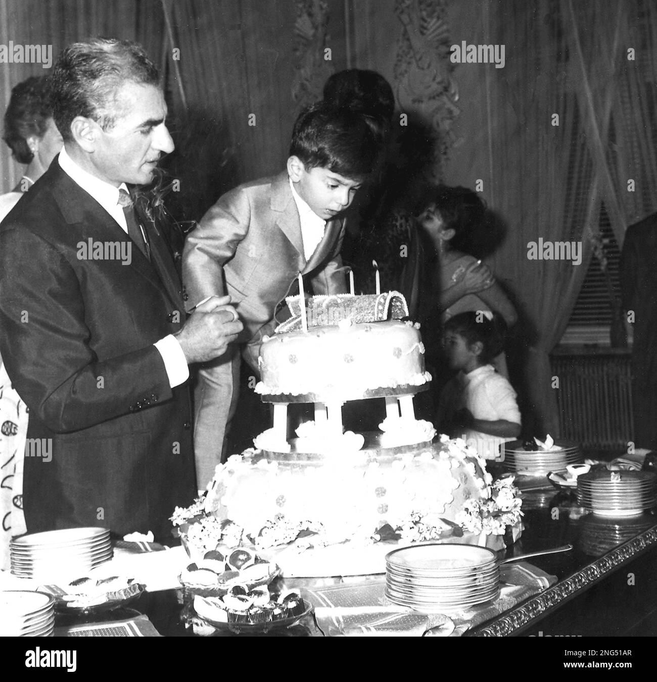 Shah of Iran, Mohammad Reza Pahlavi, helps his son, Crown Prince of ...