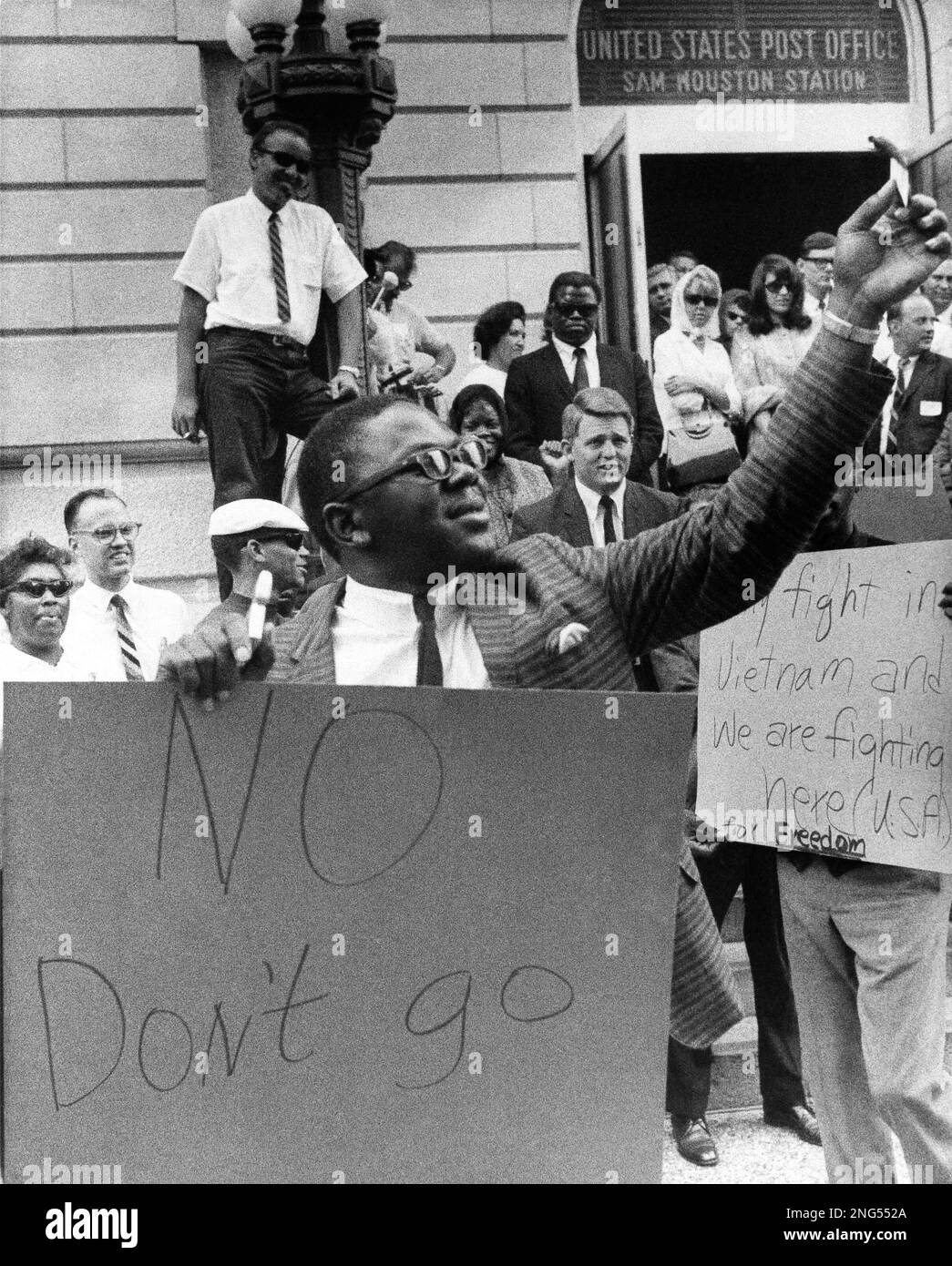 A follower of Cassius Clay burns what he called his draft card in front ...