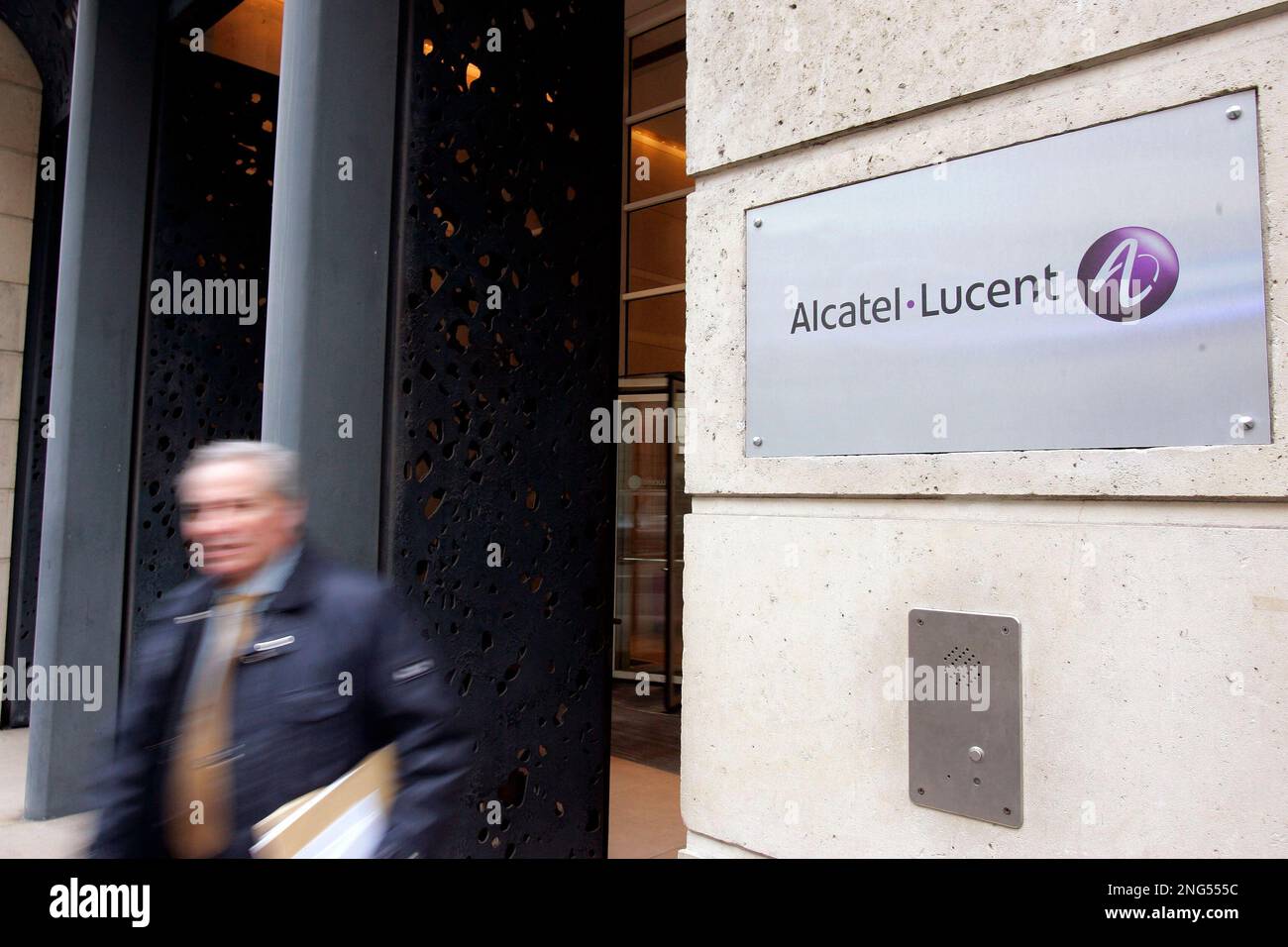 **FILE** A man leaves the headquarters of Alcatel-Lucent in Paris, in ...