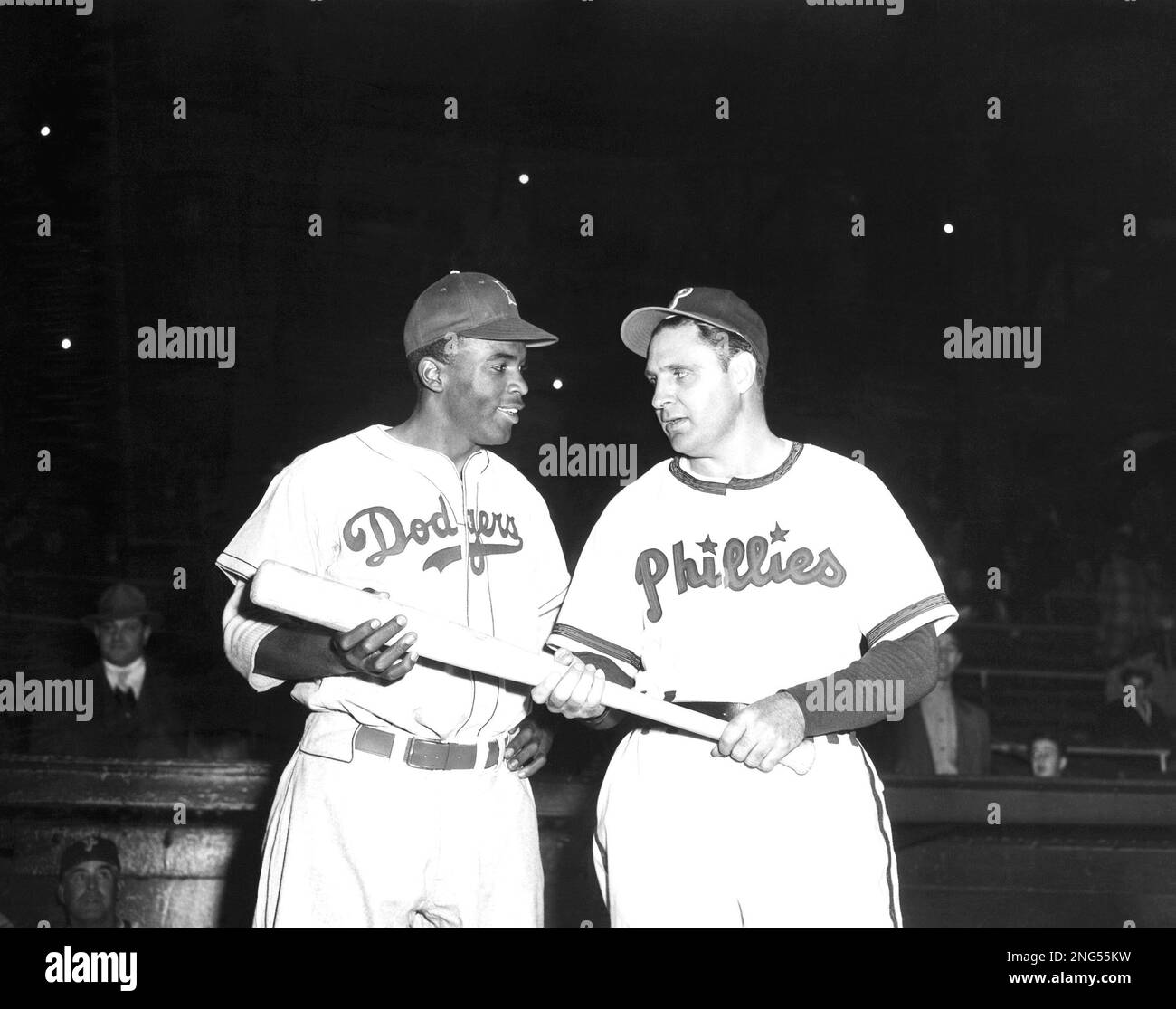 Jackie Robinson, left, Brooklyn Dodgers' first baseman, looks over the ...