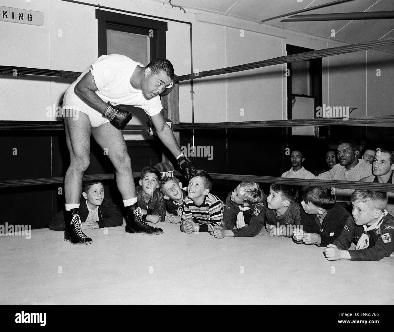 Former heavyweight boxing champion Joe Louis clowns with a group of ...