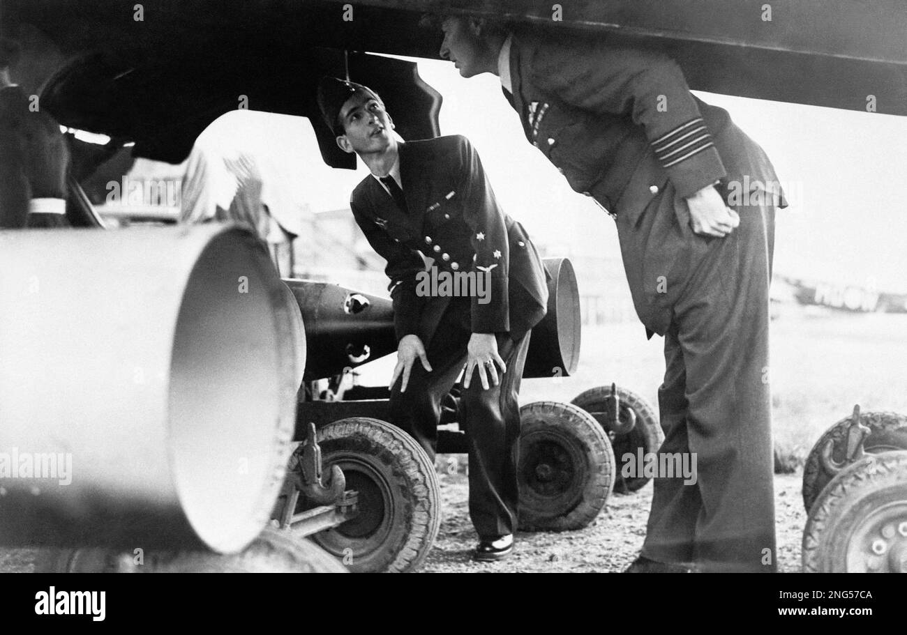 King Peter looks into a Bomb Hatch standing underneath a British Bomber ...