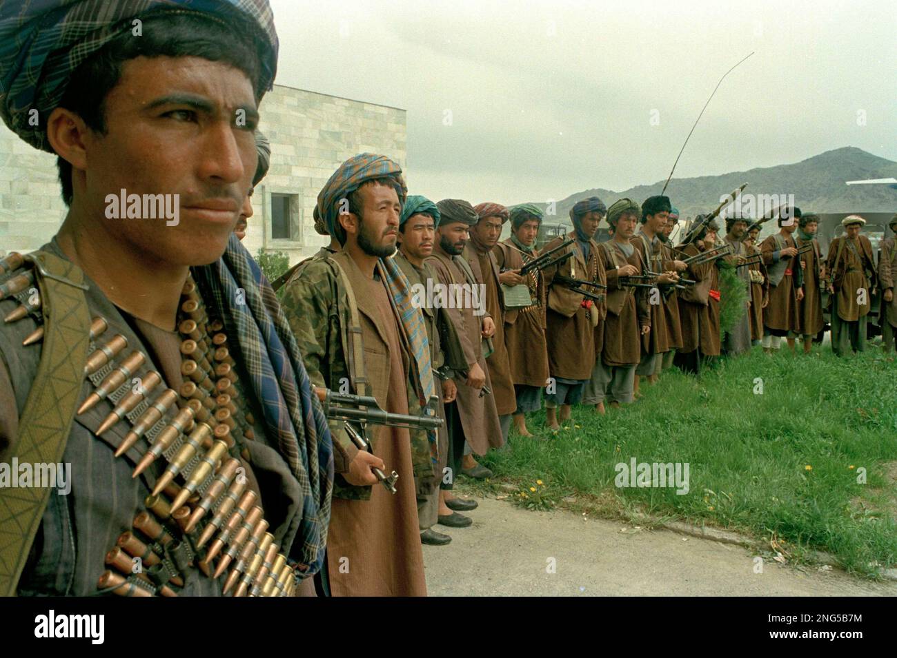 Various factions of mujahedeen fighters form a line of guards at the ...