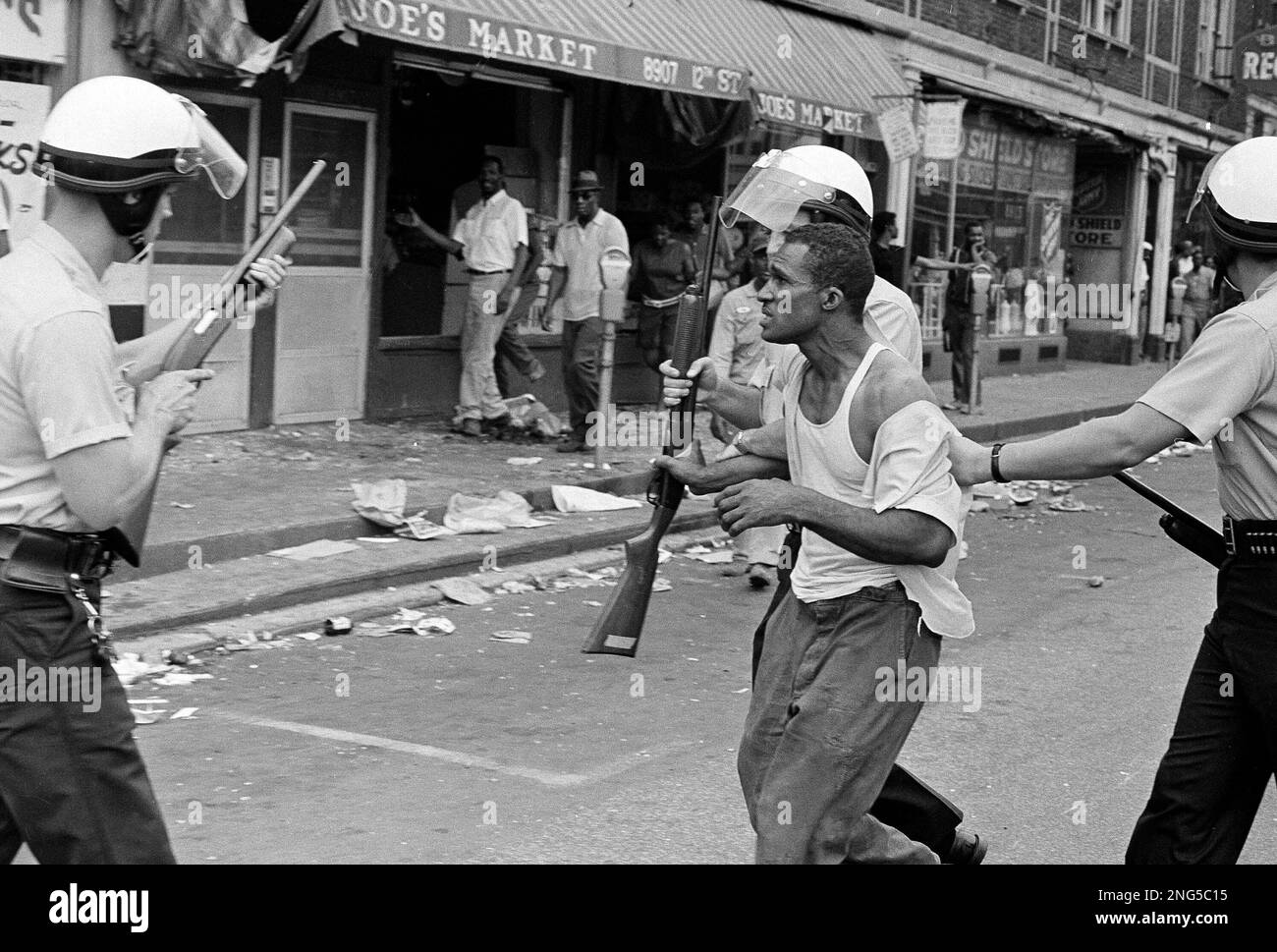 A man is taken into custody during a race riot in Detroit, July 23 ...