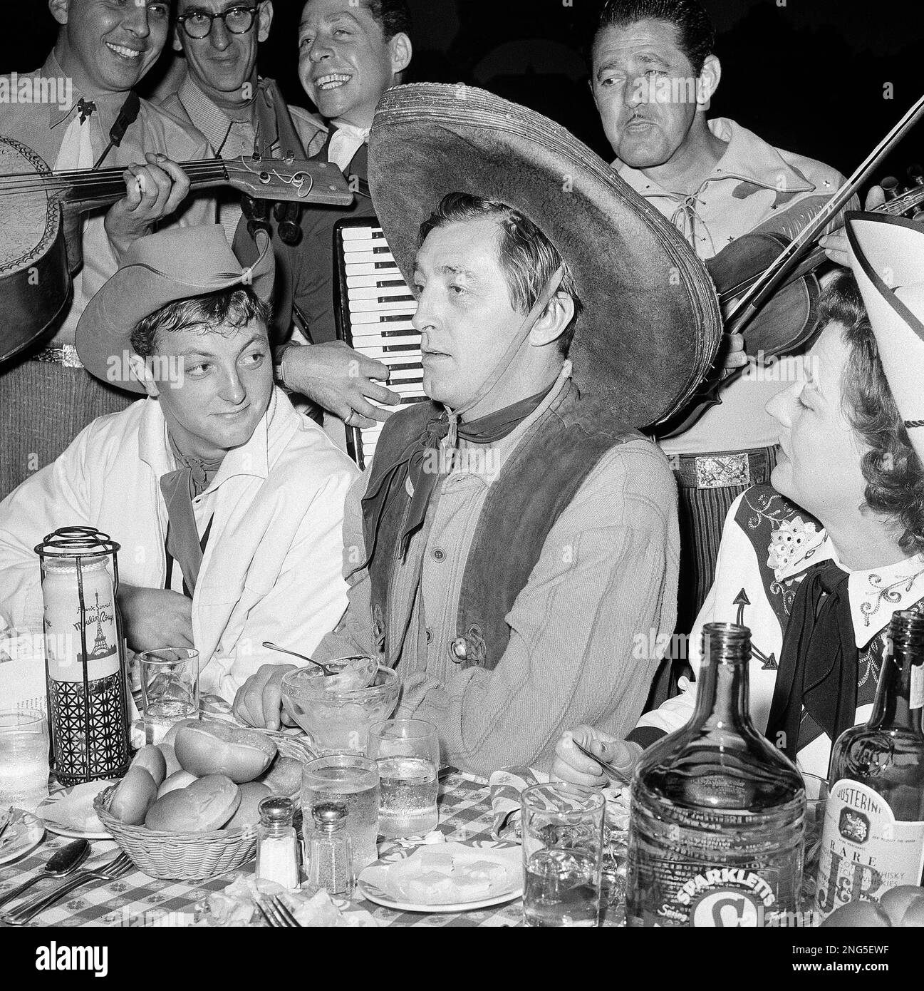 Actor Robert Mitchum; dressed as a Mexican; and his son, Jim, listen ...