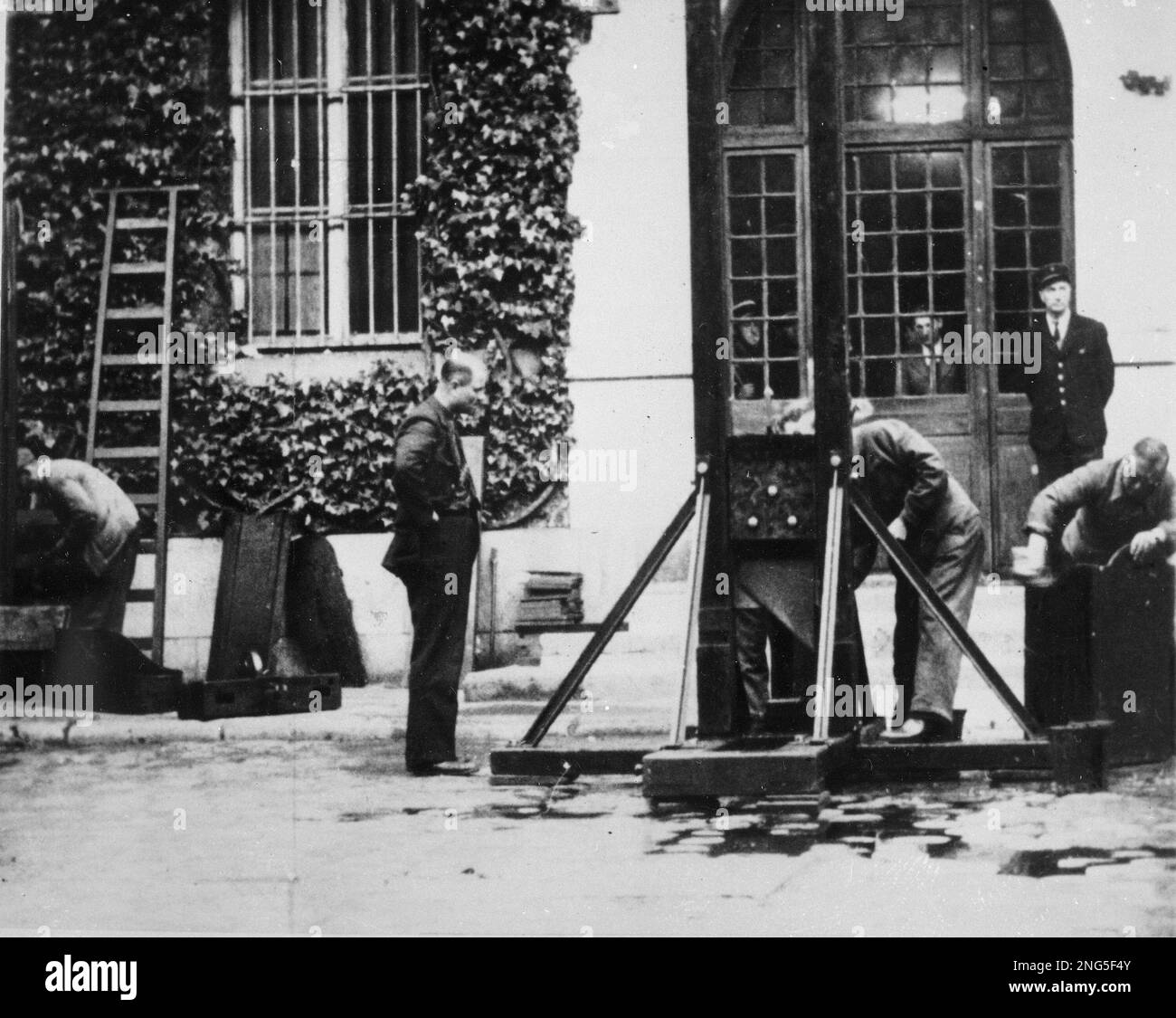 Workmen in the La Sante Prison courtyard clean and dismantle the ...