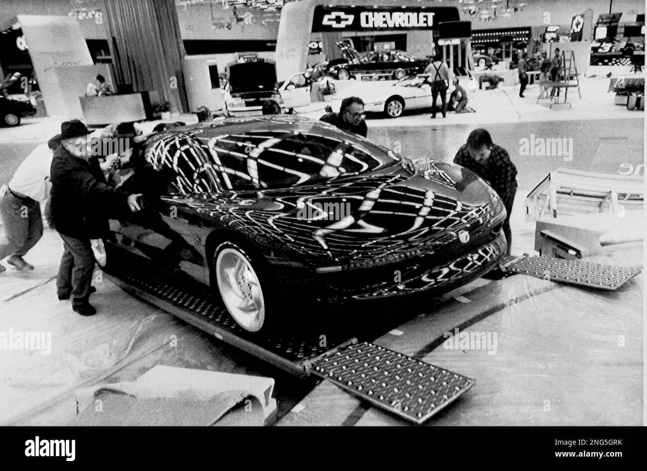 Workers roll a Mercury Cyclone concept car up a ramp into its display ...