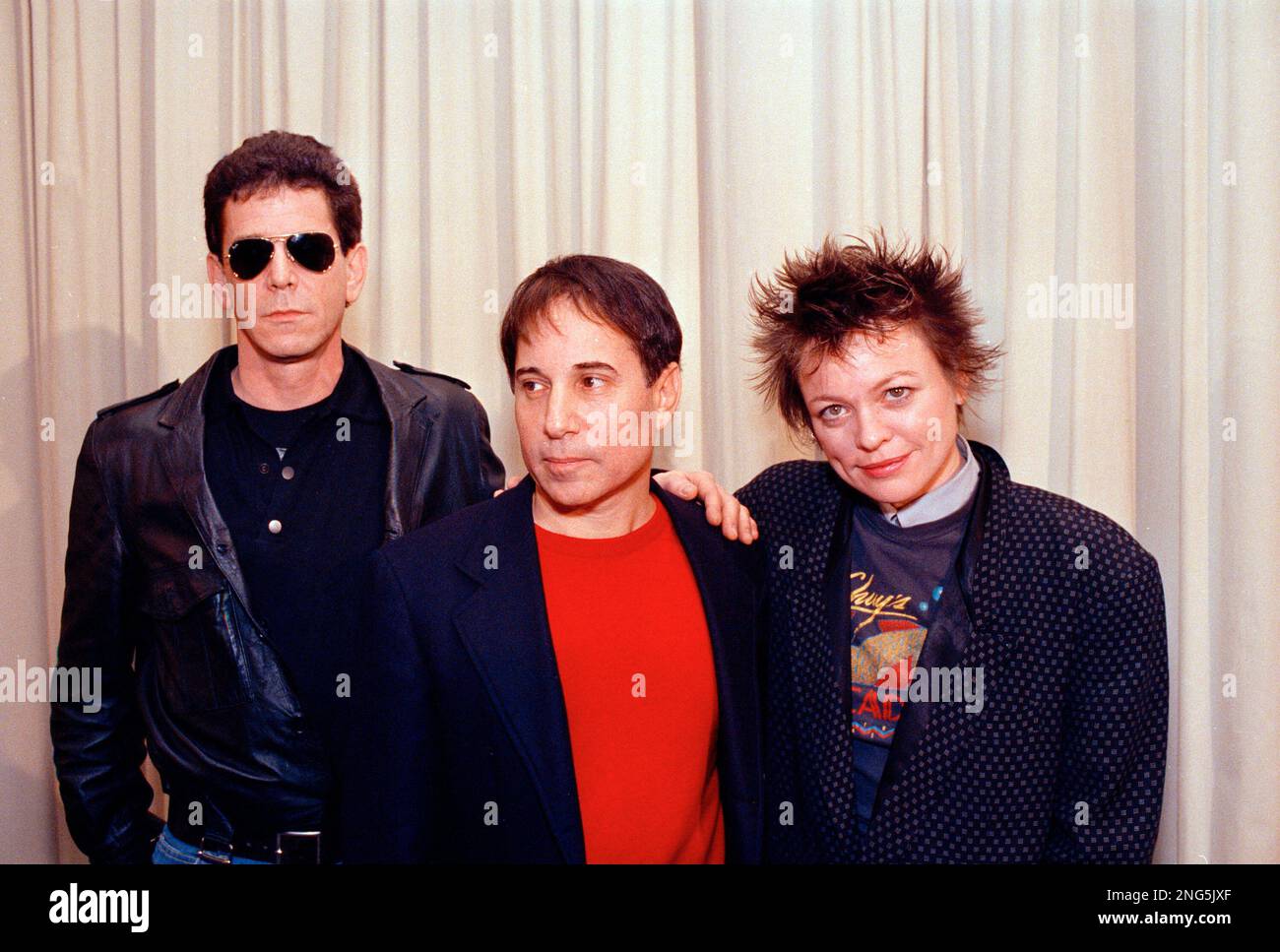 Singer-songwriter Paul Simon is flanked by musicians Lou Reed, left ...