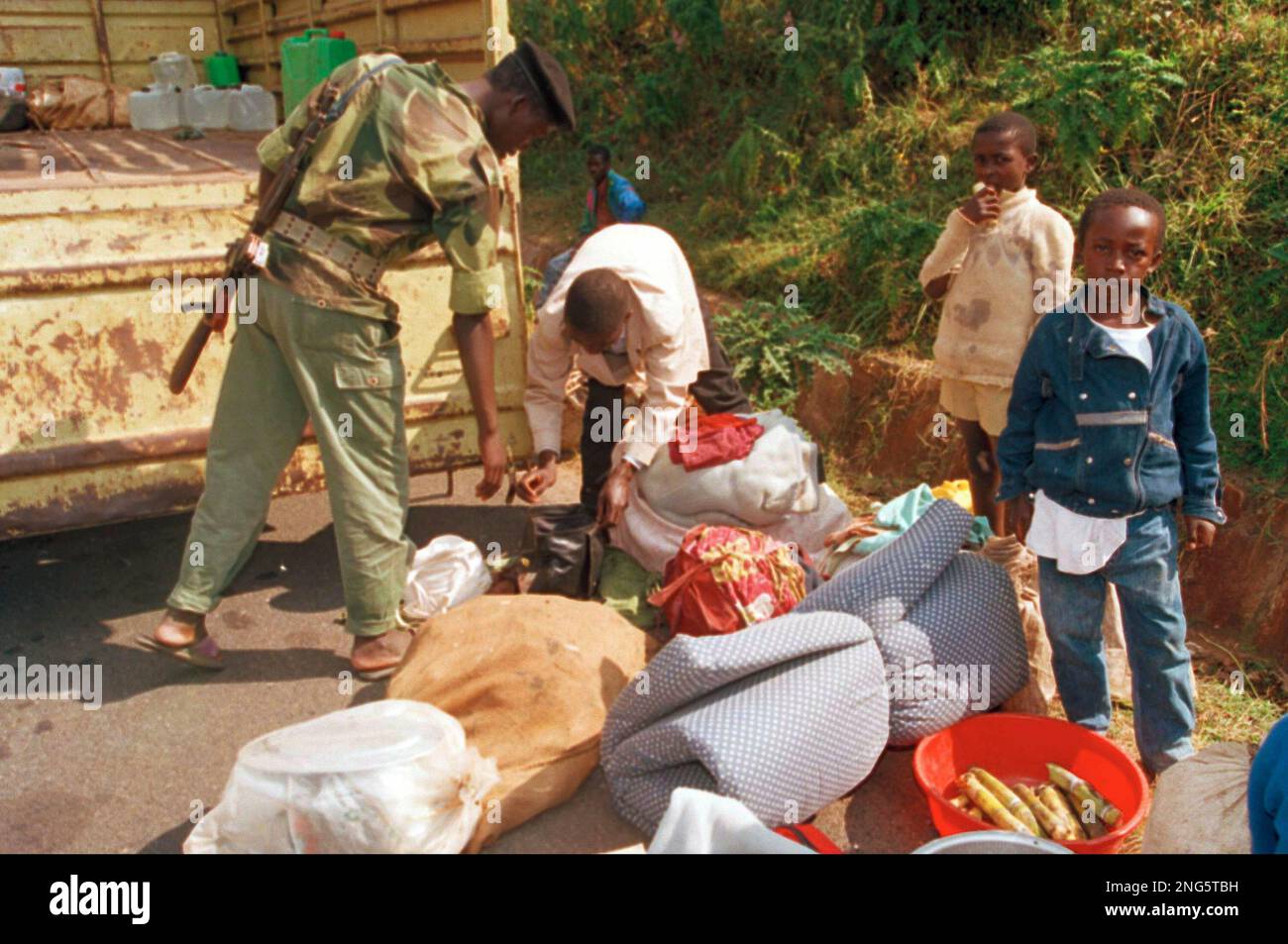 A soldier from the Rwanda Patriotic Fron (RPF) checks the belongings of ...