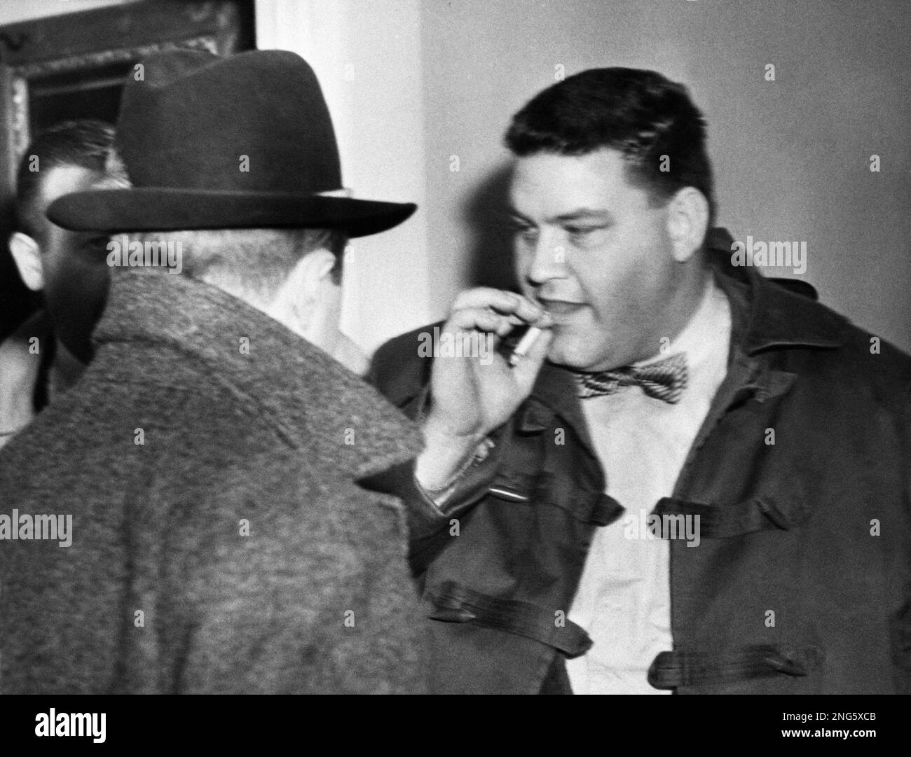Ferdinand W. Demara Jr., right, puffs on a cigarette outside courtroom ...