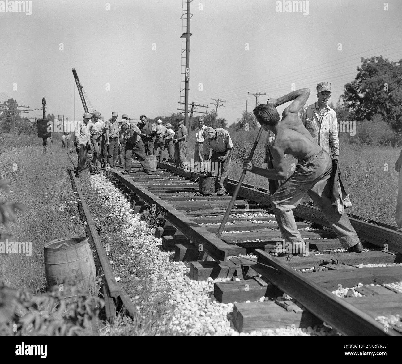 The heavy 112-pound rail easily is swung into position by a crane while ...
