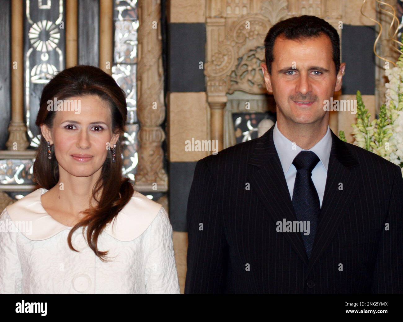 Syrian president Bashar Assad and his wife Asma standing together ahead ...