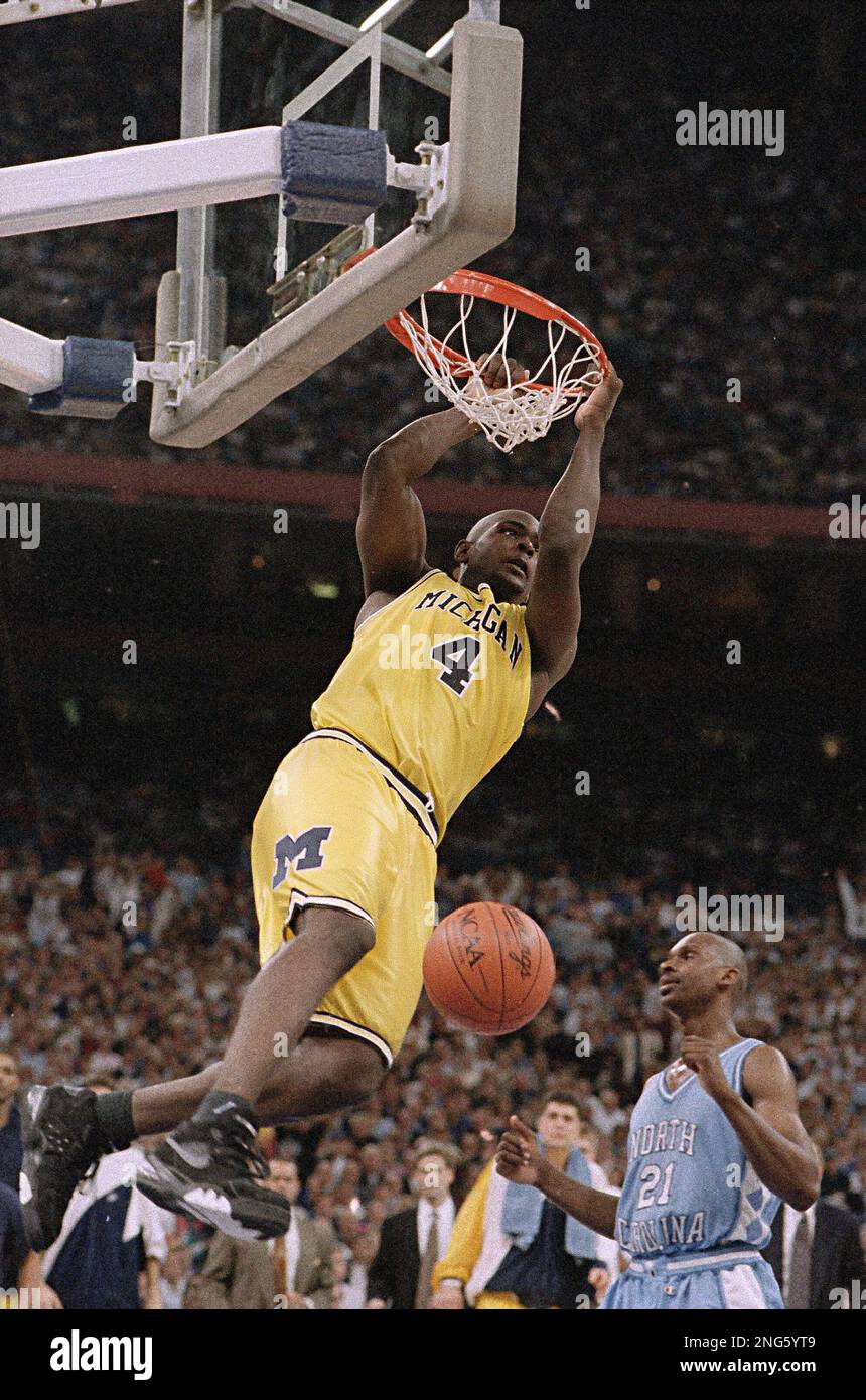 Michigan's Chris Webber hangs from the rim after dunking the ball ...