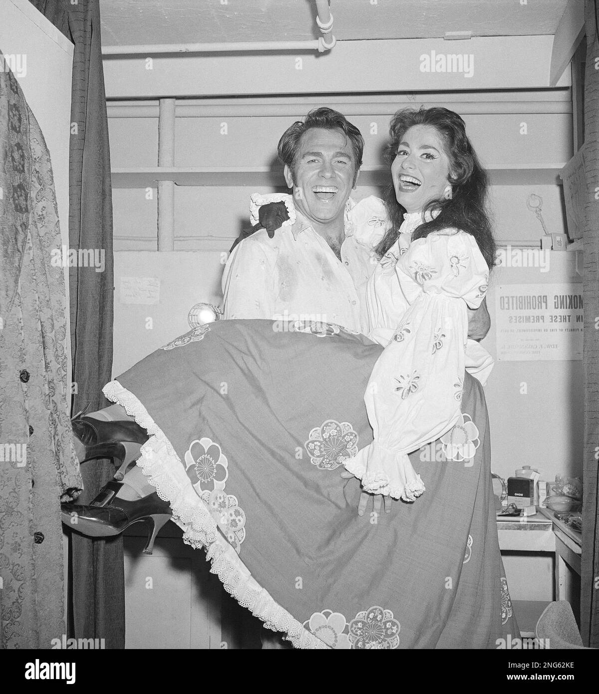 Howard Keel, left, carries Carol Lawrence into dressing room backstage ...