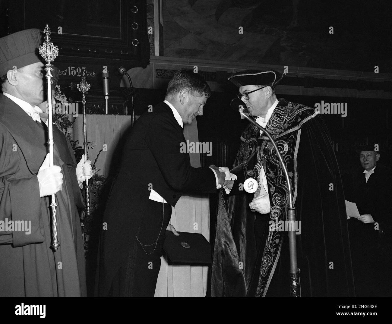 Prof. Wilhelm Walcher, president of Marburg University, Germany, hands ...