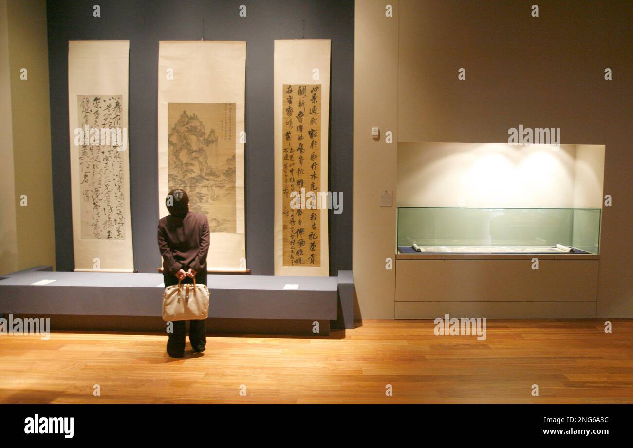 A visitor looks at hand-painted scrolls during a press tour of the ...