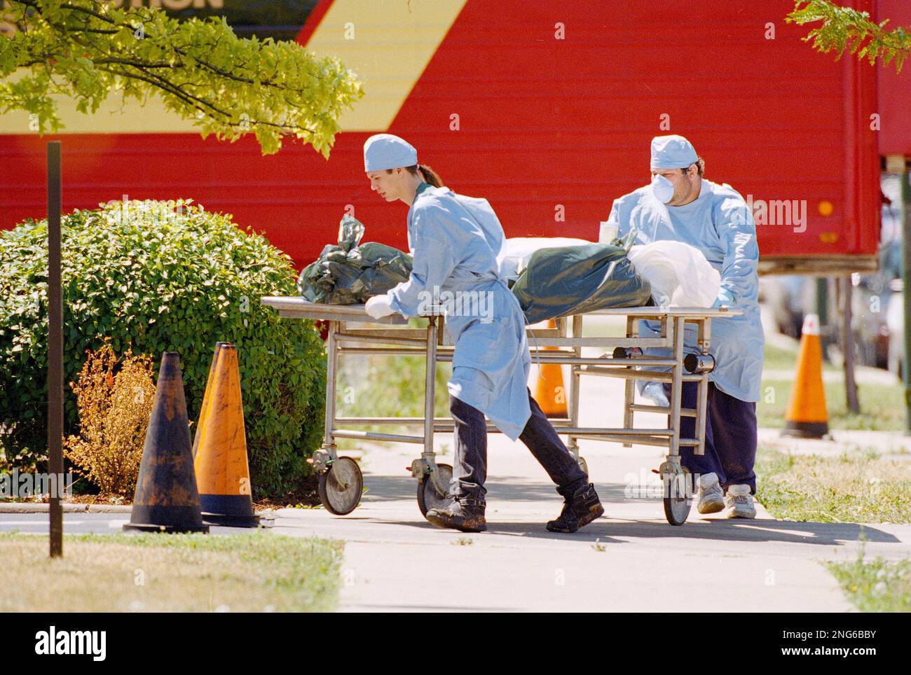 Workers at the Cook County morgue in Chicago wheel a body to ...