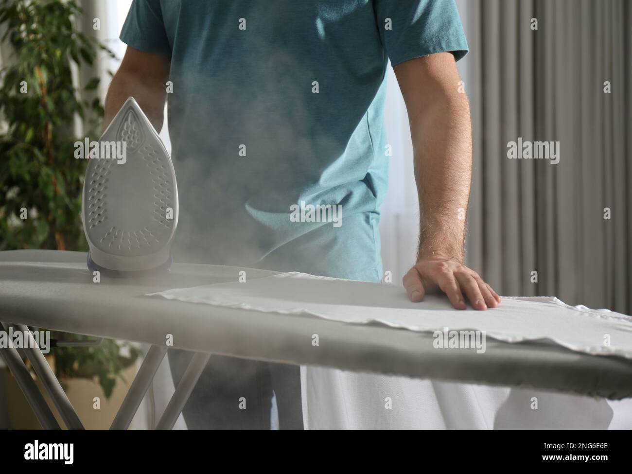 Man ironing clean shirt hi-res stock photography and images - Alamy