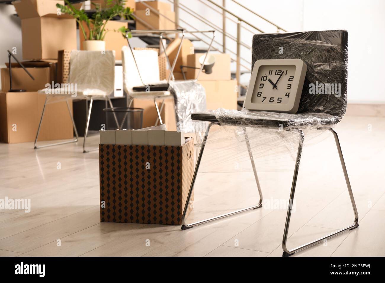 Packed chair, box and clock in office. Moving day Stock Photo - Alamy