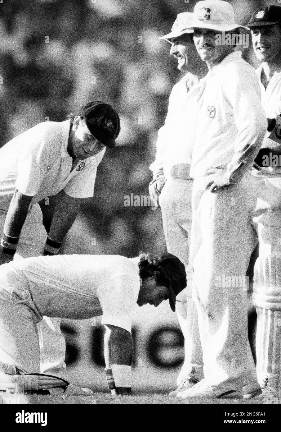 England's batsman Allan Lamb bends over in pain after a ball bounced up ...