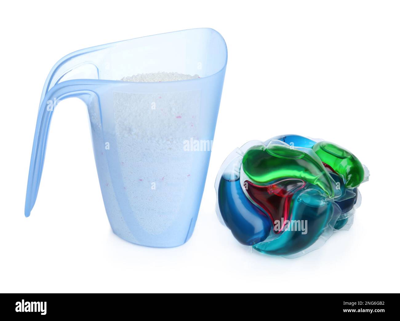 Laundry capsules and measuring cup of washing powder on white ...