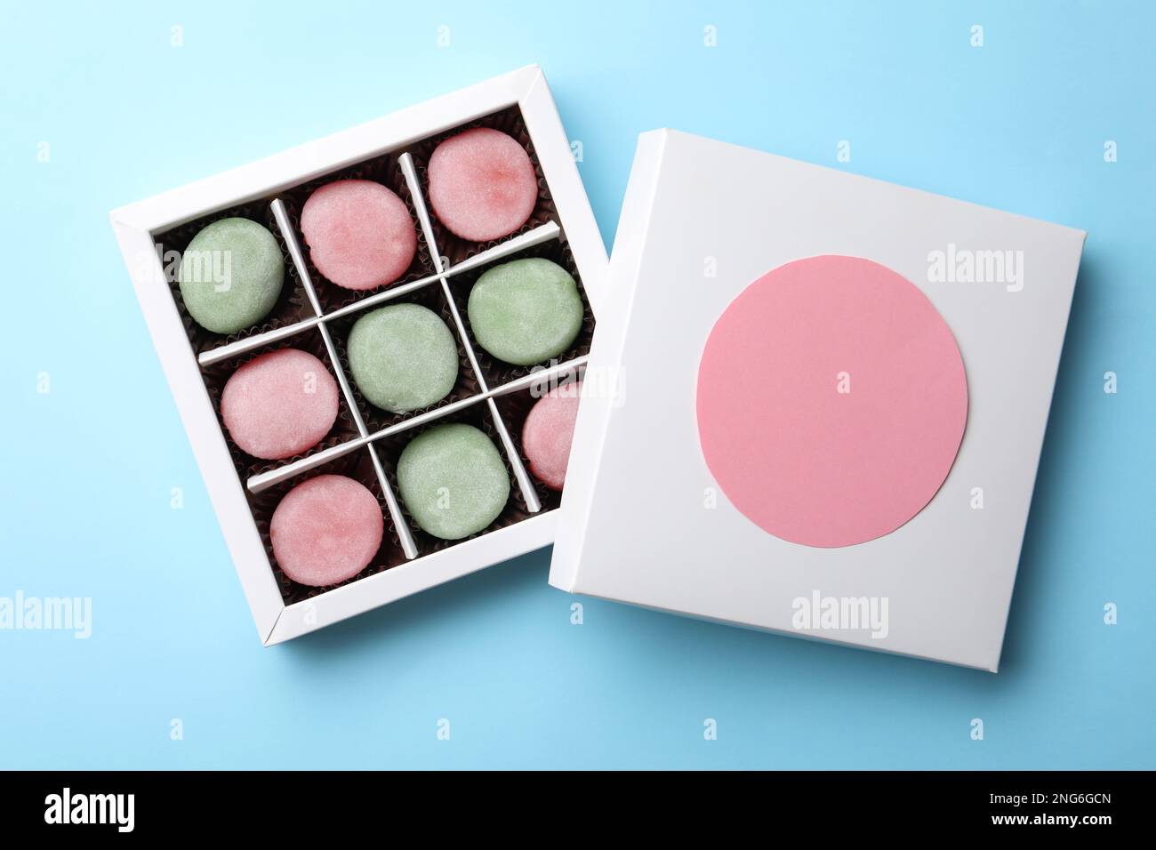 Many different delicious mochi in box on light blue background, top ...