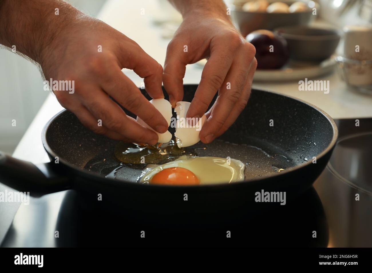 Man cooking eggs in frying pan, closeup Stock Photo - Alamy