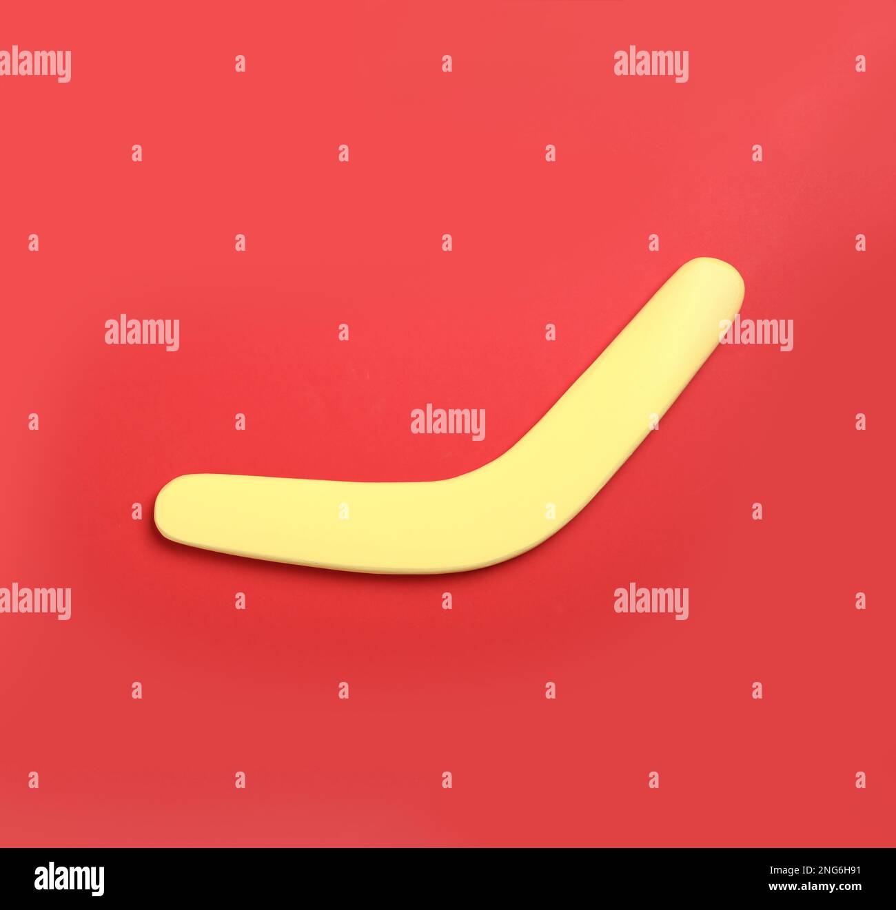 Yellow wooden boomerang on red background, top view Stock Photo - Alamy
