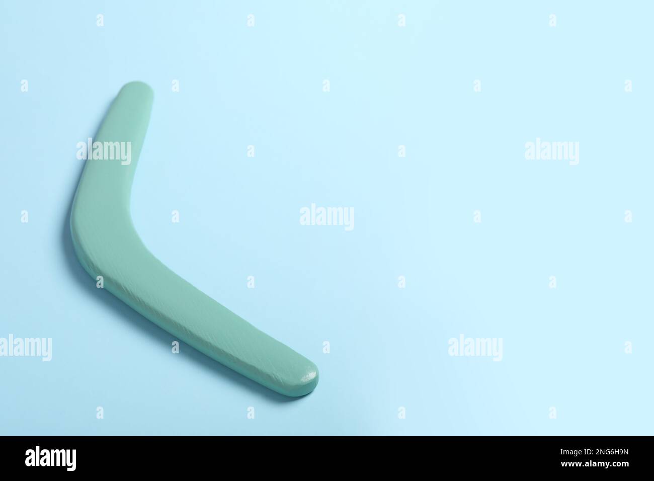 Wooden boomerang on light blue background. Space for text Stock Photo ...