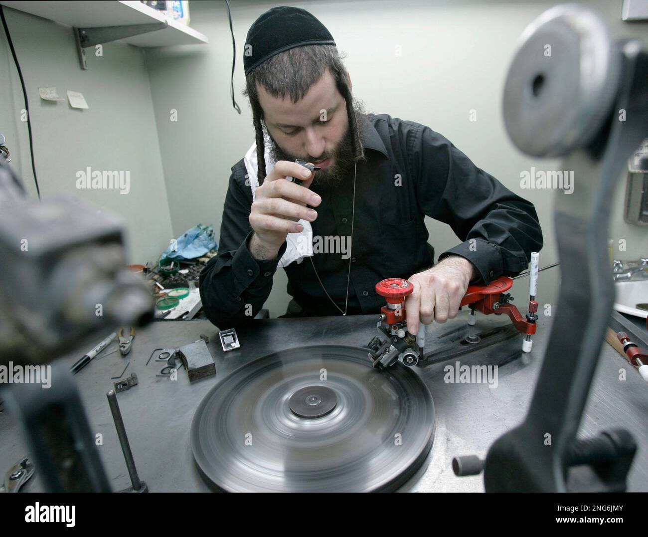 Diamond cutter Moshe Brach, 29, works at cutting a round, brilliant cut ...
