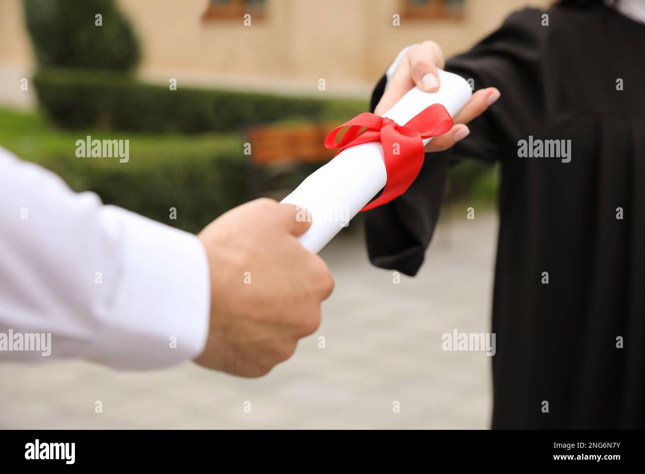 Student receiving diploma during graduation ceremony outdoors, closeup ...