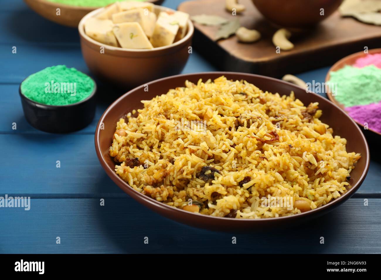 Traditional Indian food and color powders on blue wooden table. Holi ...