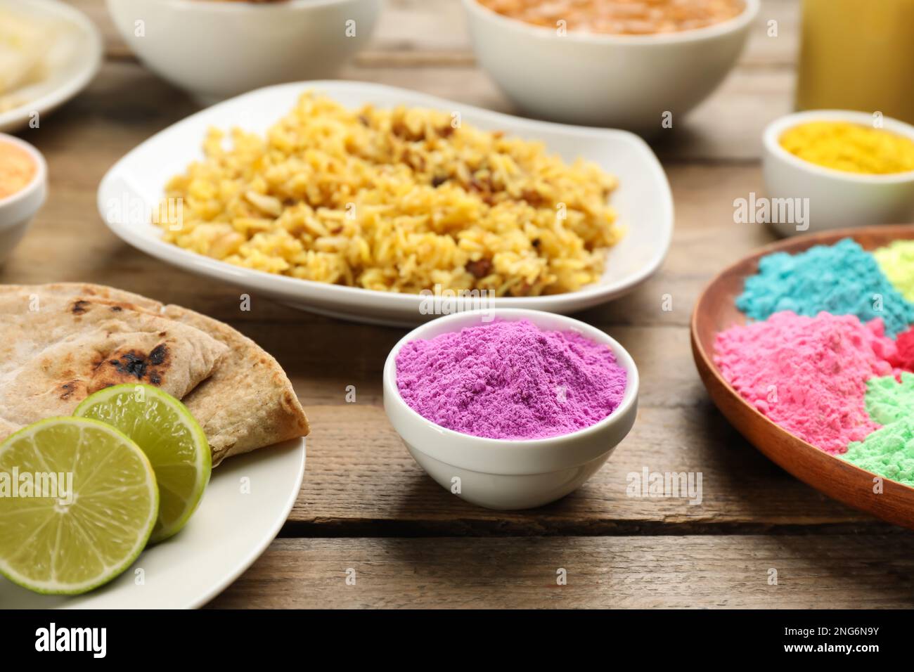 Traditional Indian food and color powders on wooden table. Holi ...