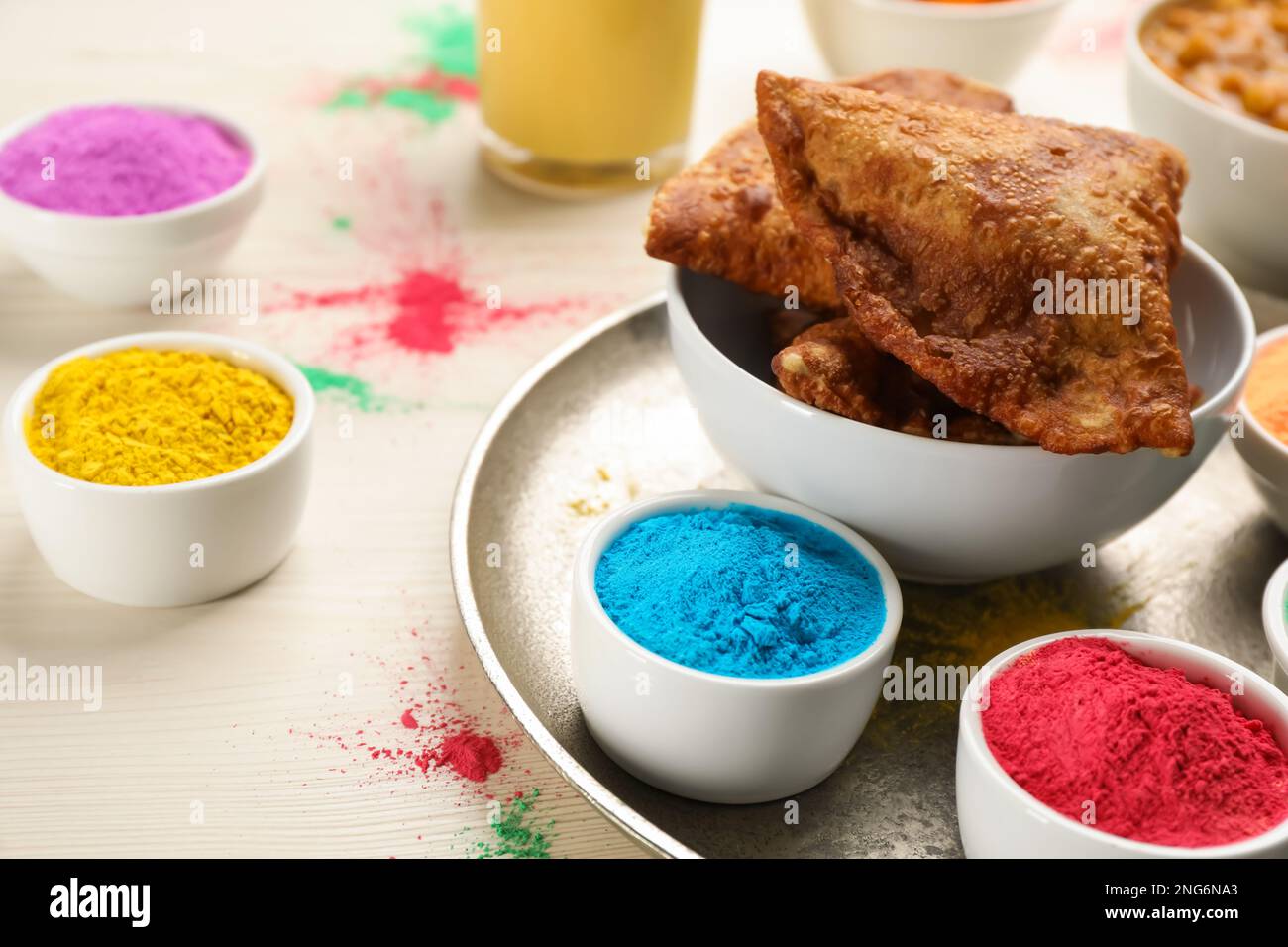 Traditional Indian food and color powders on white wooden table ...