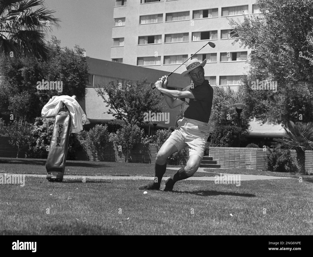 Actor and dancer Ray Bolger takes an unorthodox swing at a golf ball on ...