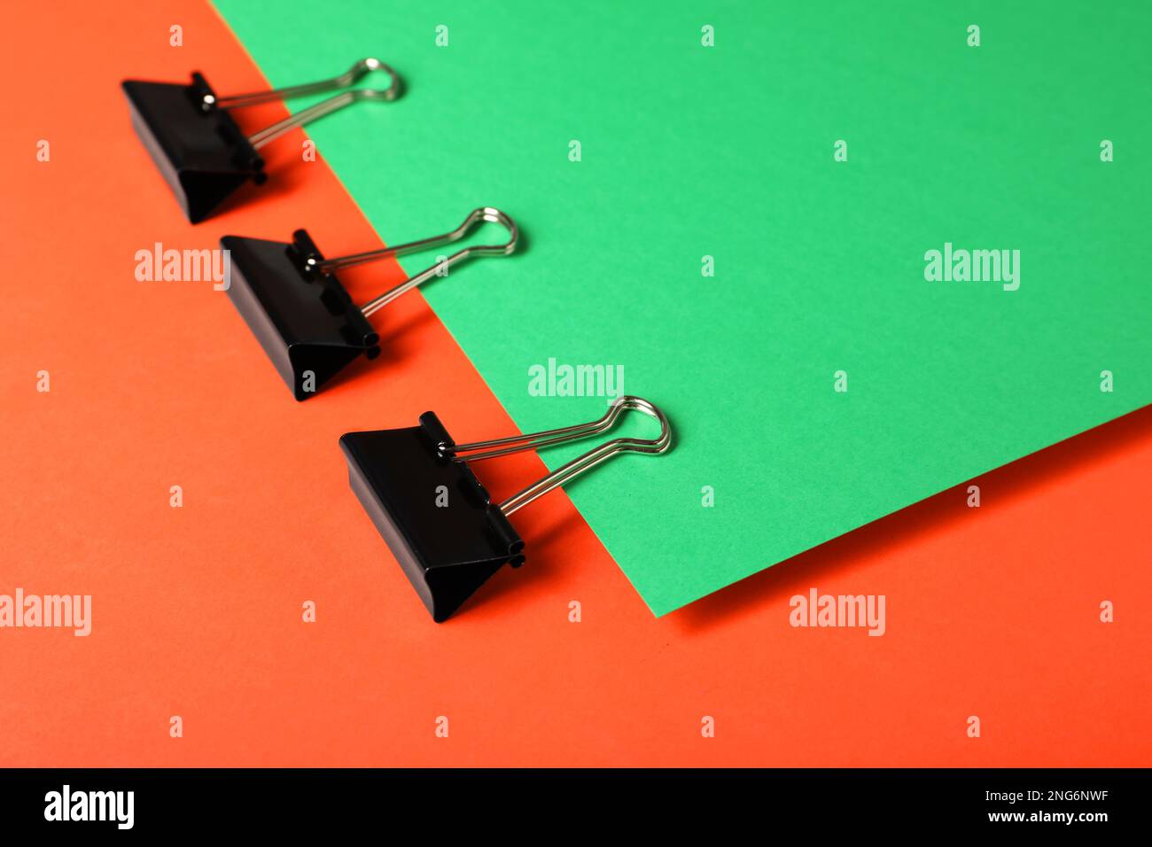 Black binder clips on color background. Stationery items Stock Photo ...