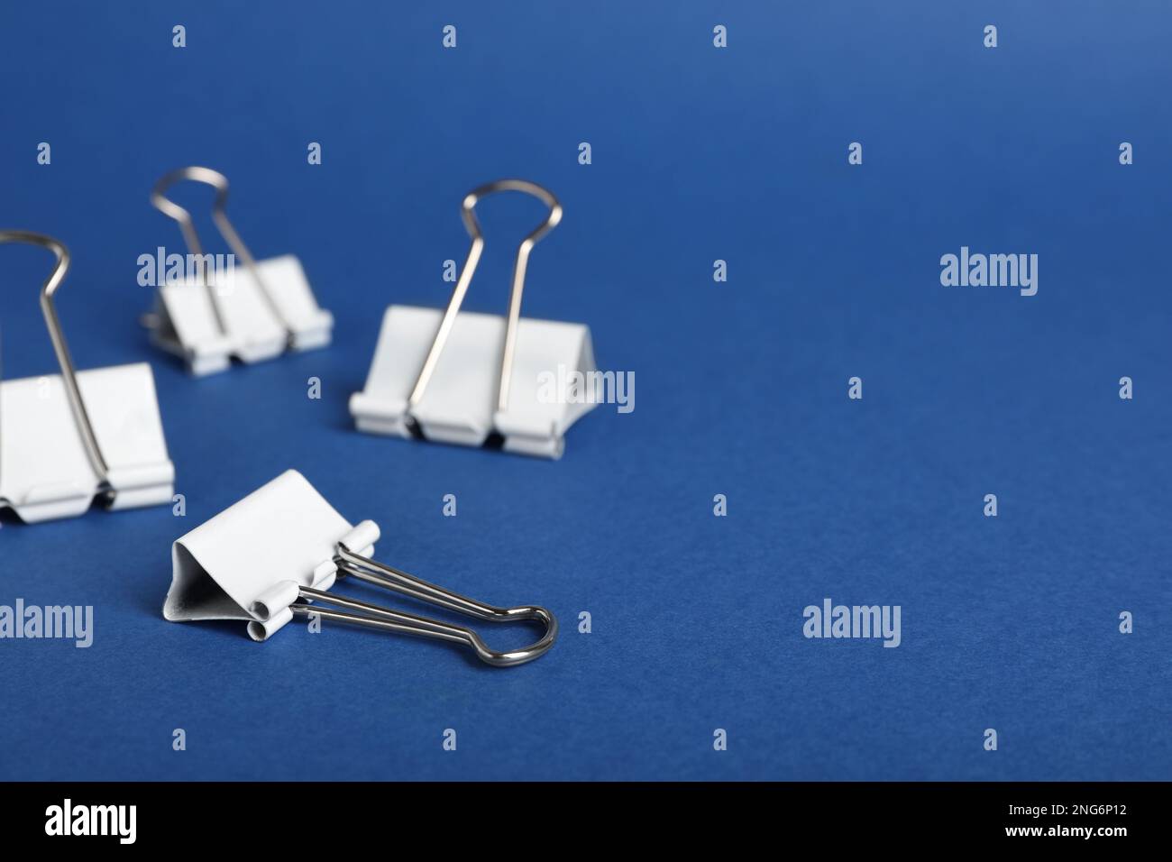 White binder clips on blue background, closeup. Space for text Stock ...