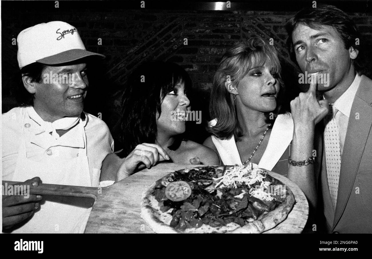 Chef Wolfgang Puck, owner of Spago Restaurant, holds a pizza as cast ...