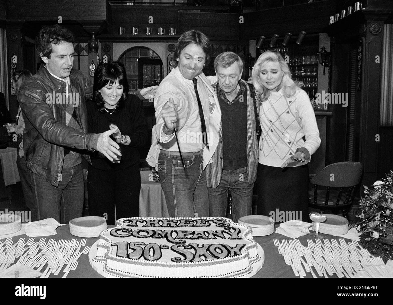 The cast of the TV sitcom "Three's Company," have a small cake and ...