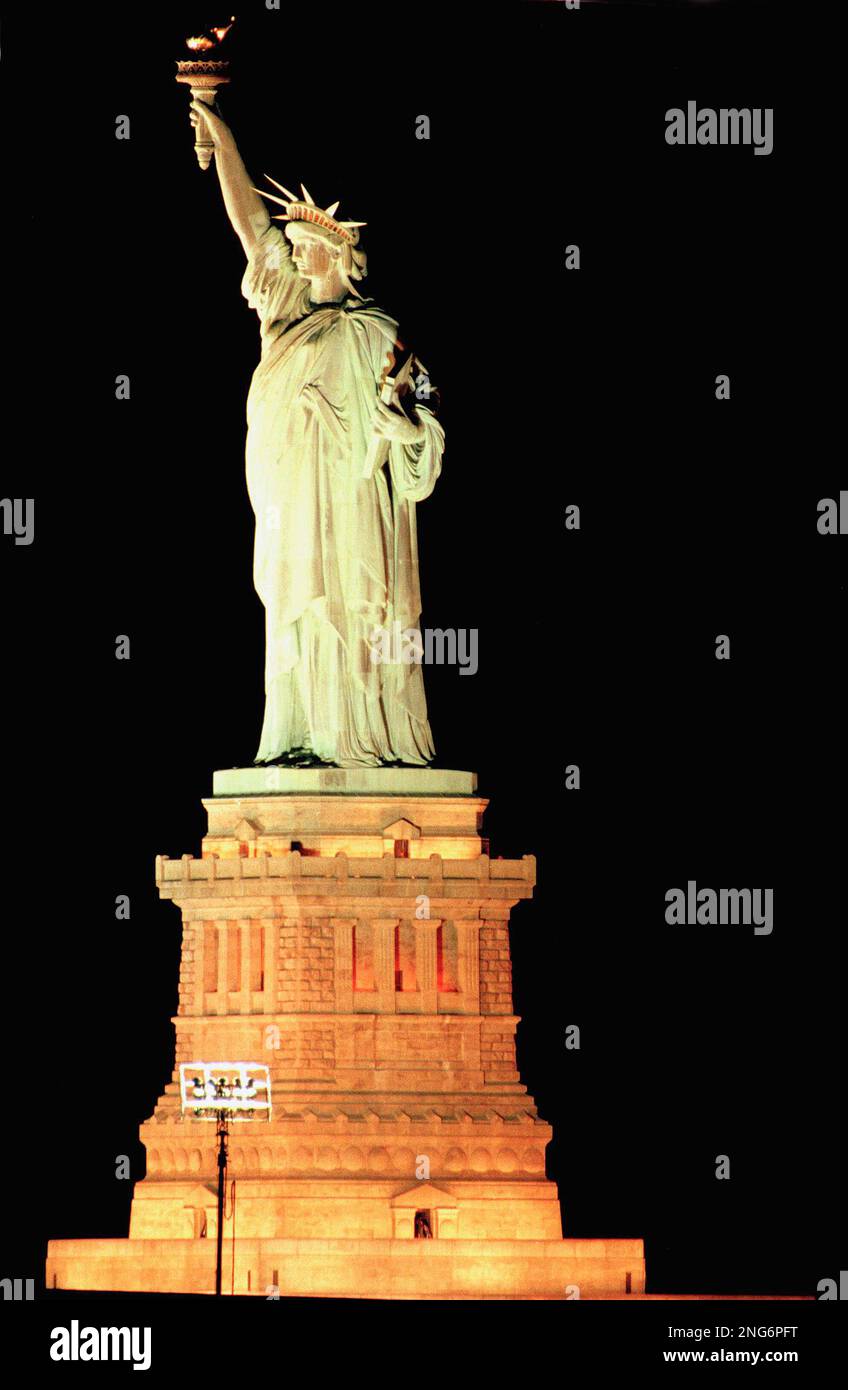 Colored lights bathe the base of the Statue of Liberty as President ...