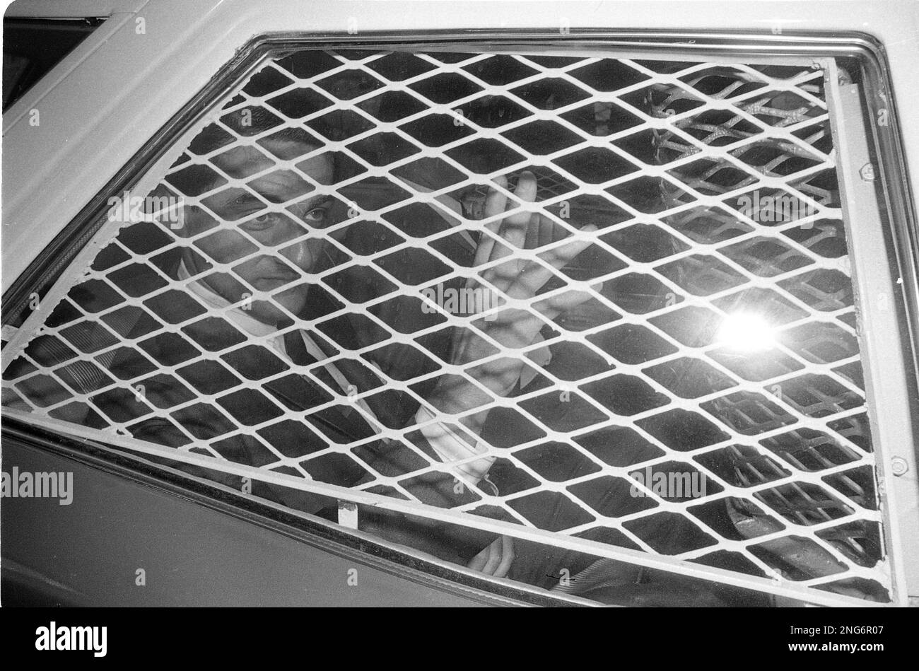 Dr. Carl A. Coppolino waves from the caged back seat of a police car ...