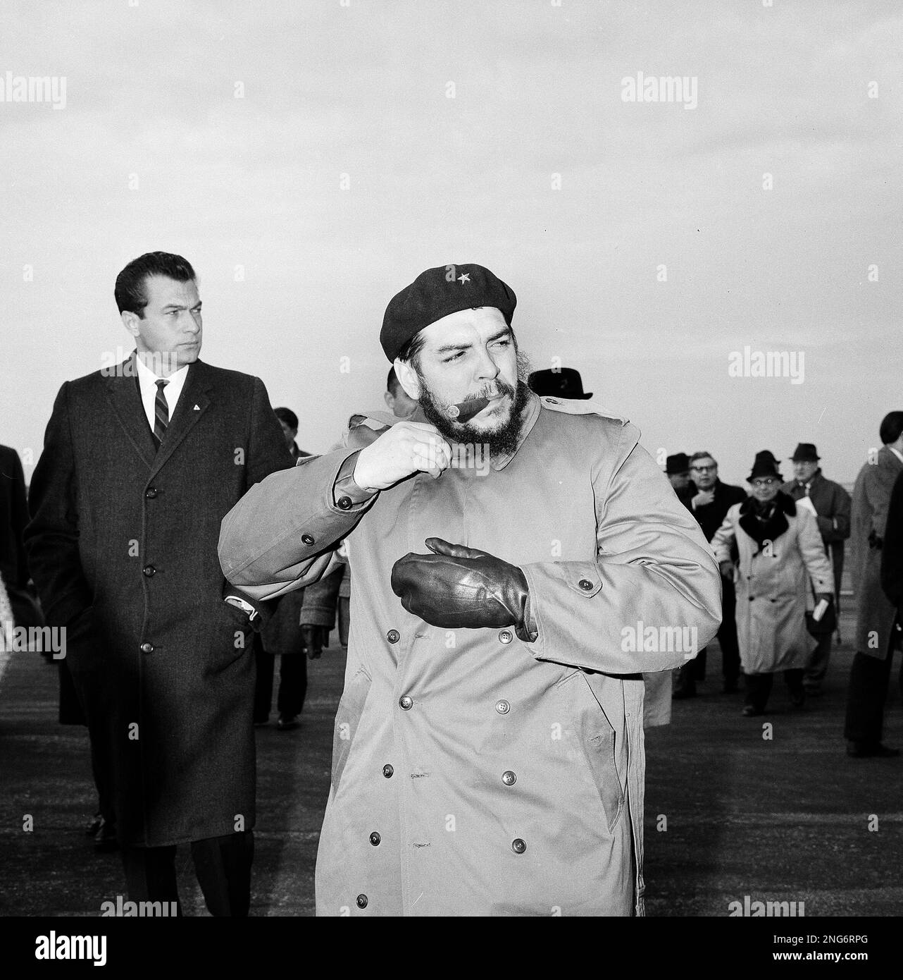 Cuba's Minister of Industry, Ernesto "Che" Guevara, buttons his coat at ...