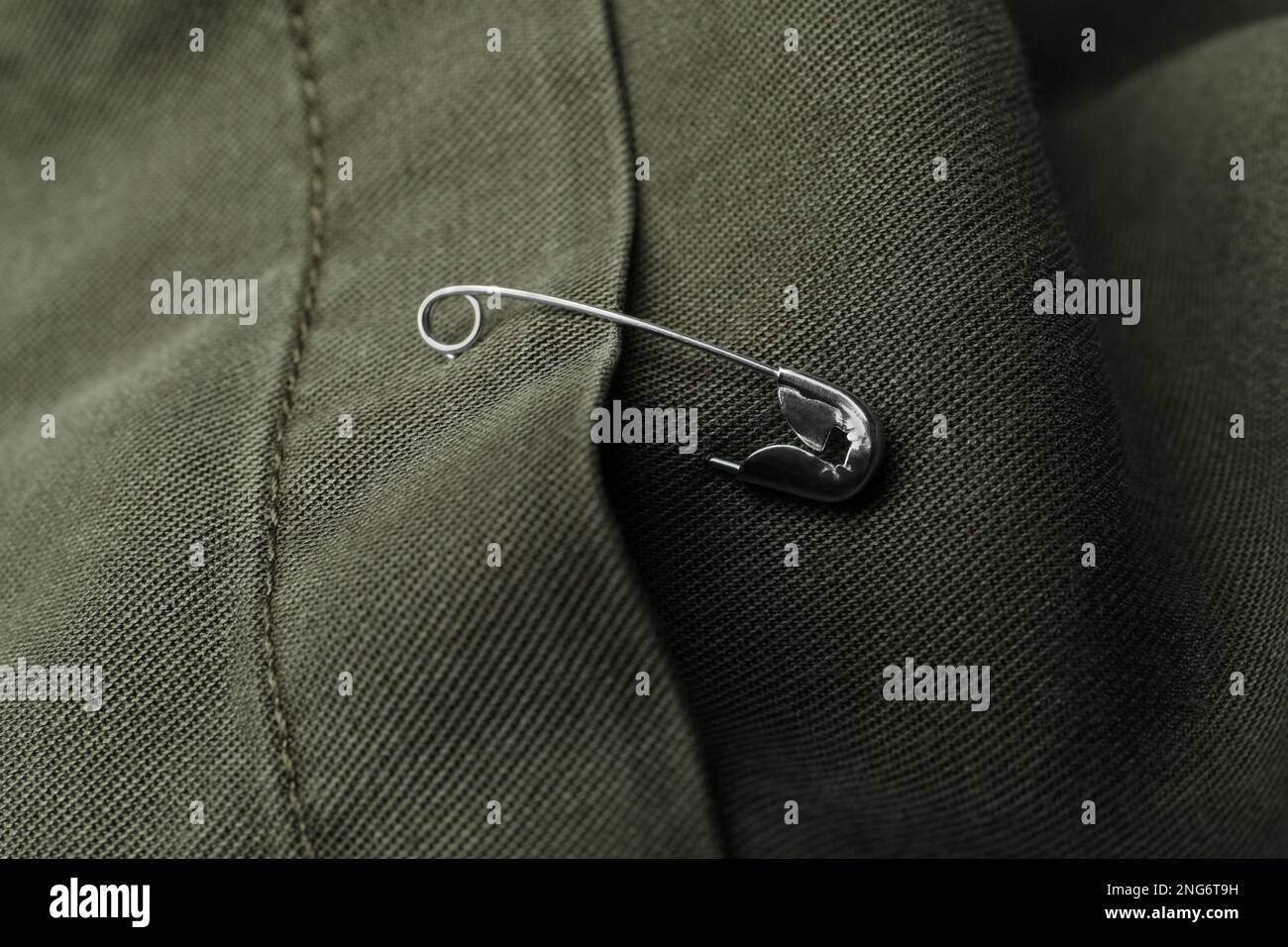 Closeup view of metal safety pin on clothing Stock Photo - Alamy
