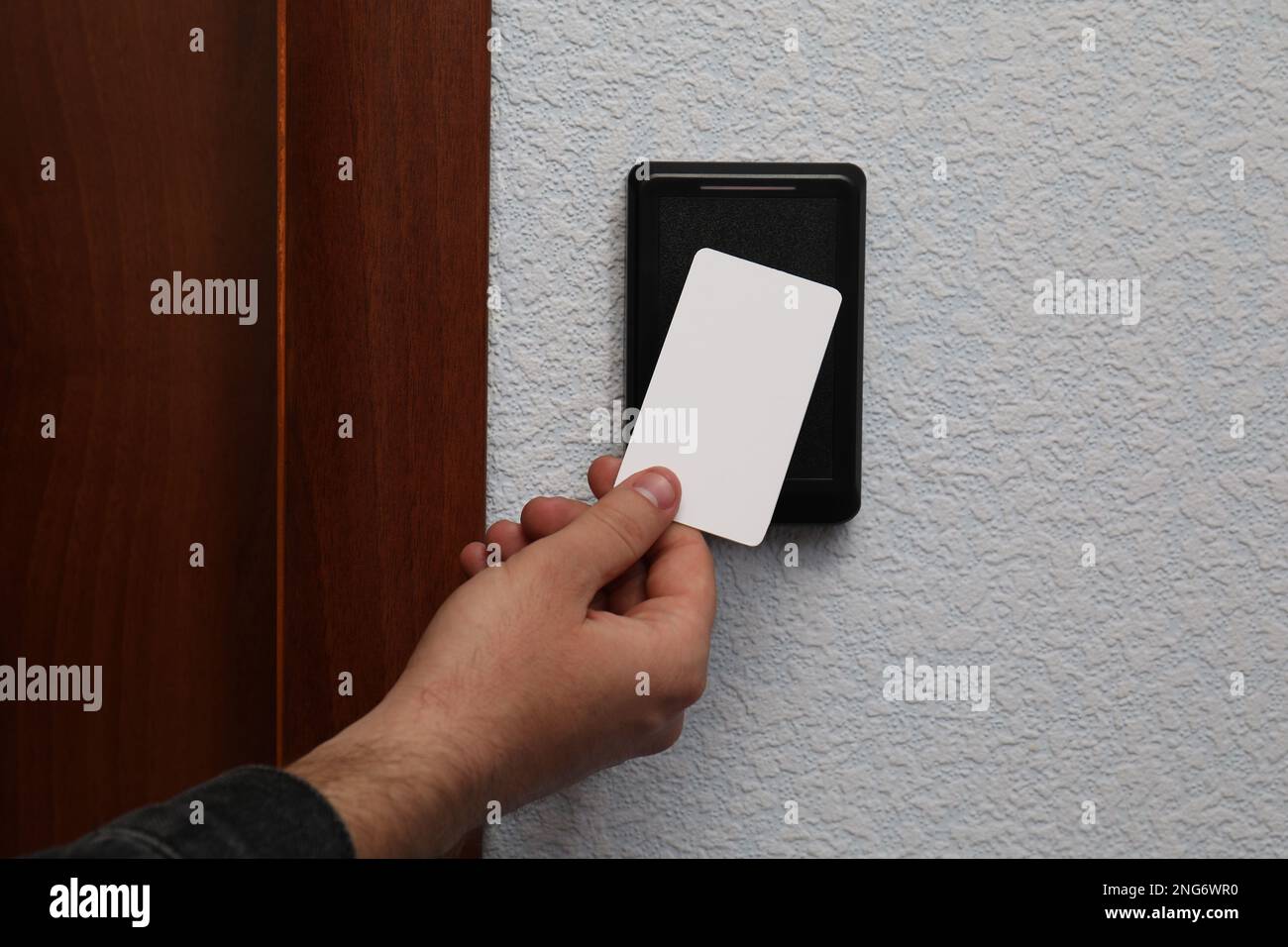 Man opening magnetic door lock with key card indoors, closeup Stock ...